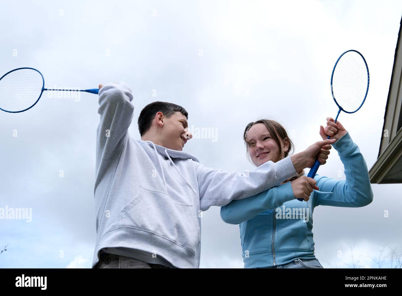 badminton rackets boys girl swing each other with racket background of ...