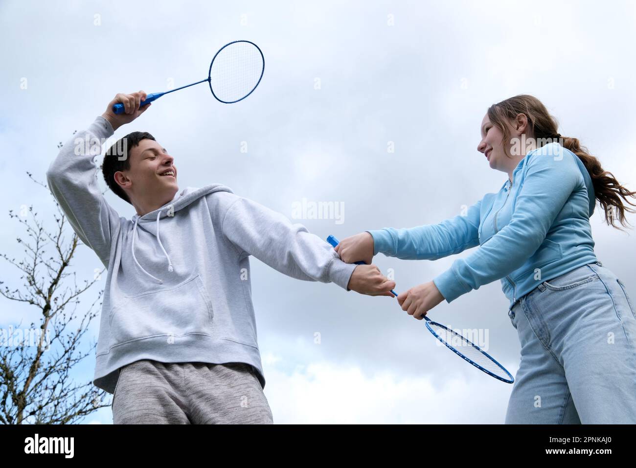 badminton rackets boys girl swing each other with racket background of ...