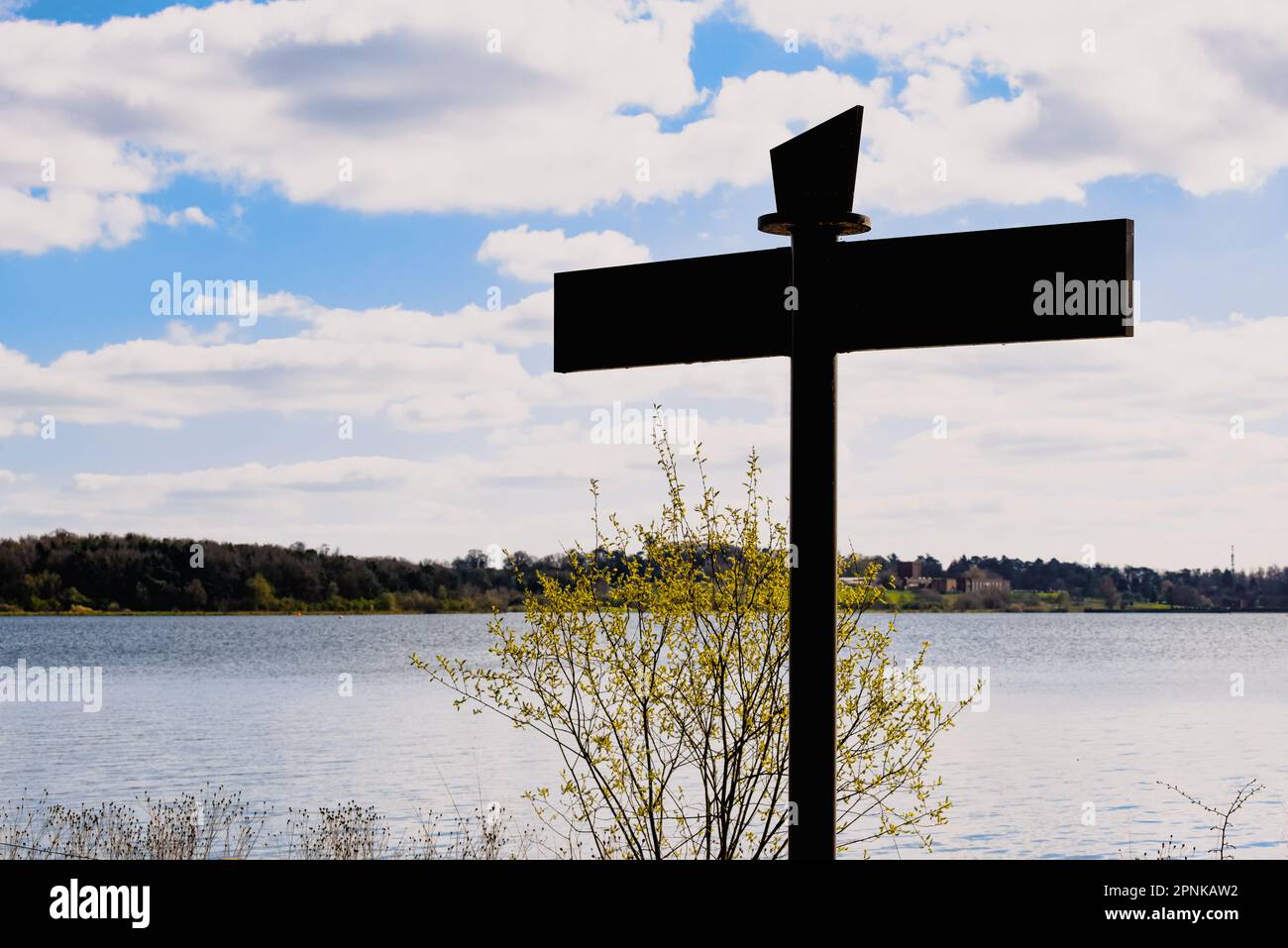 Sign post pointing out directions over a lake and landscape background ...