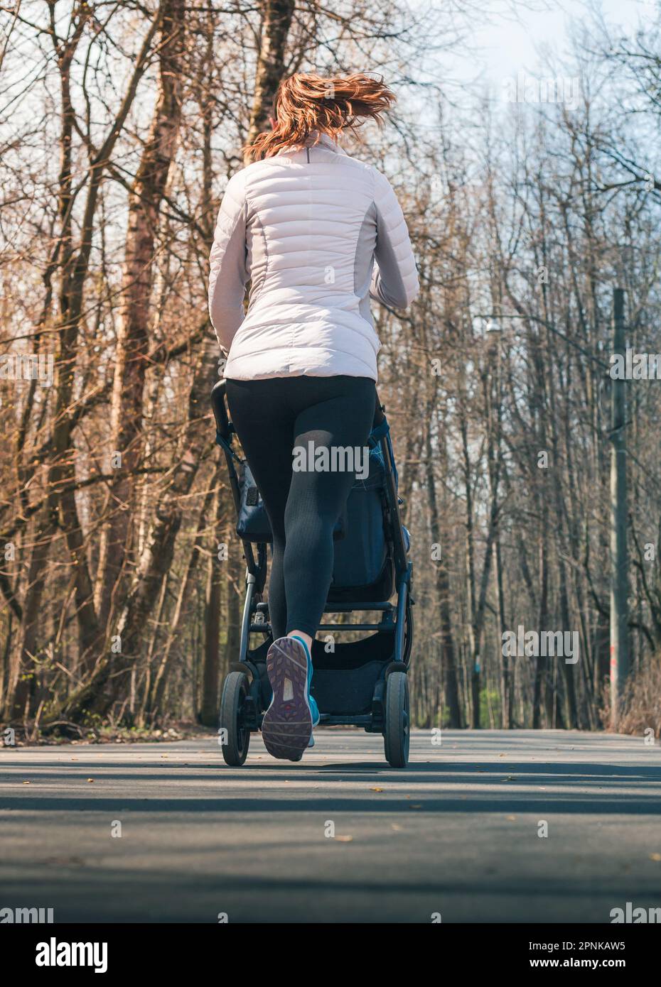 Lifestyle happy mother running with baby stroller in forest Stock Photo ...
