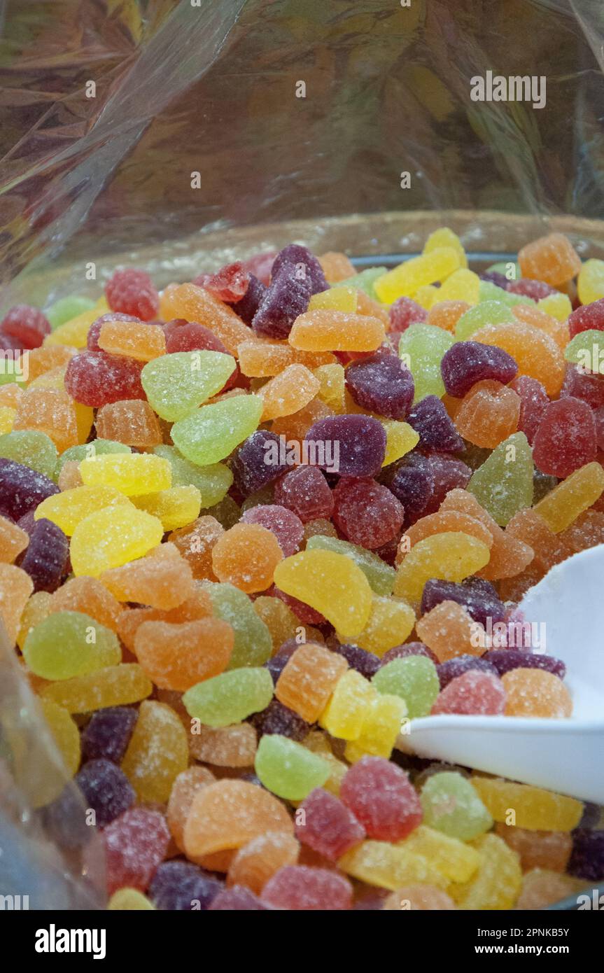 A large heart of bright multicolored round candies, dragees on a blue ...