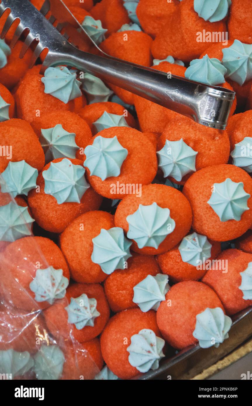 A large heart of bright multicolored round candies, dragees on a blue ...