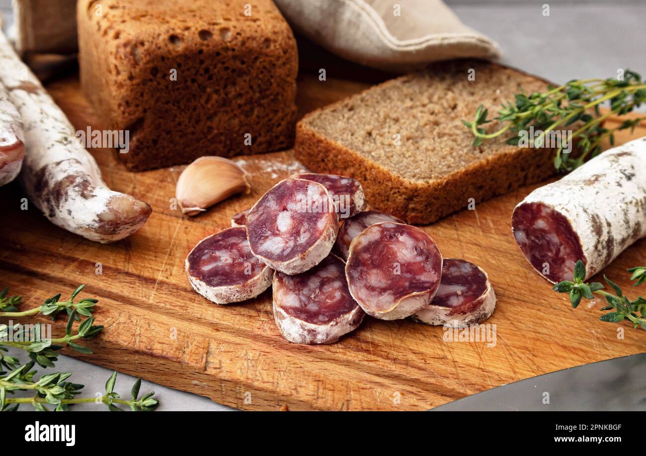 Spanish fuet sausage sliced on a board Stock Photo - Alamy