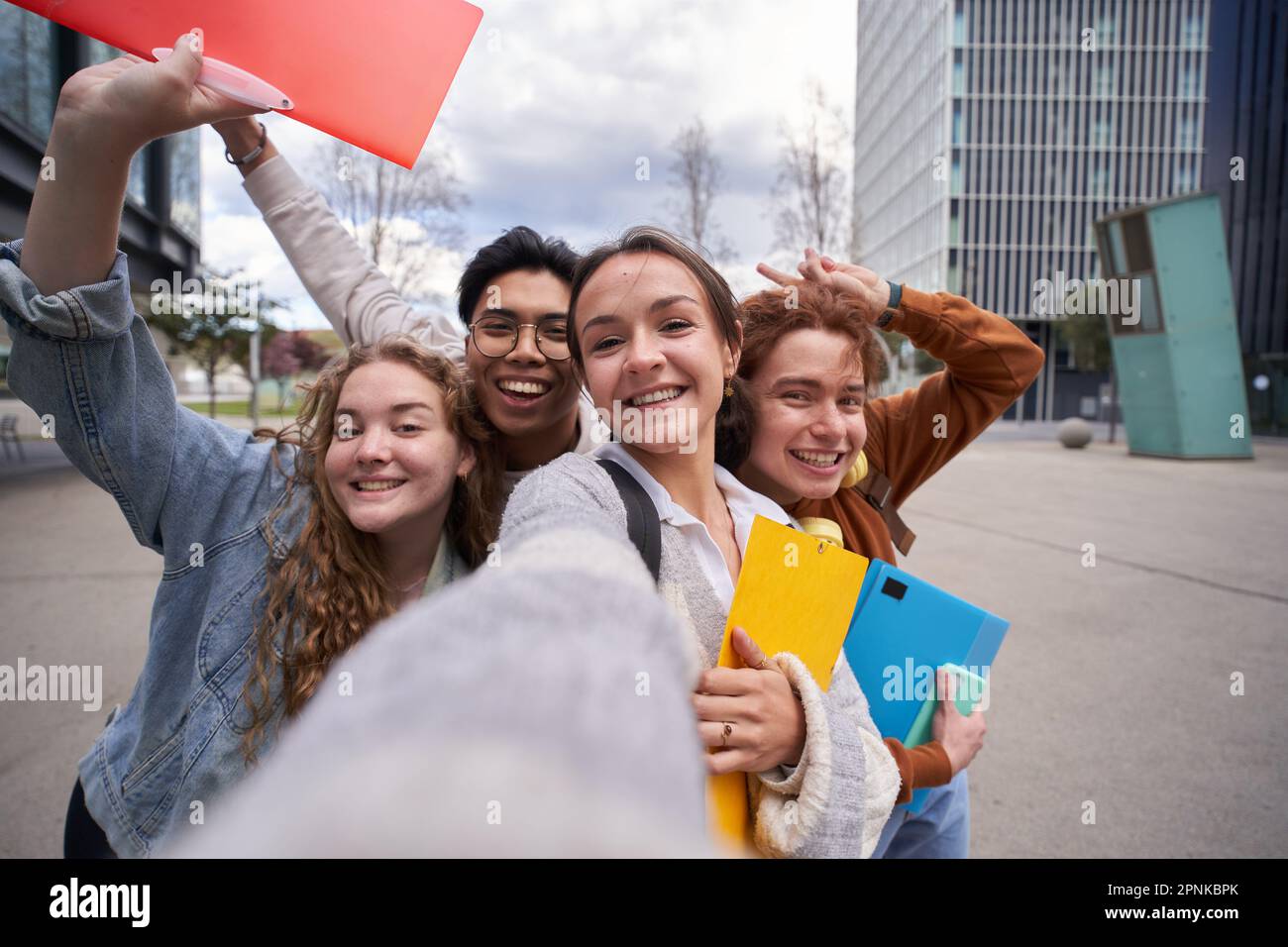 Smiling multiracial college students taking a selfie back to school ...