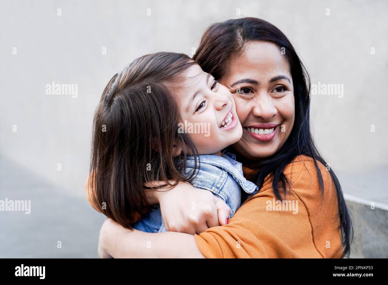 Happy Asian mother and daughter hugging each outdoor - Family love concept - Focus on child face ...