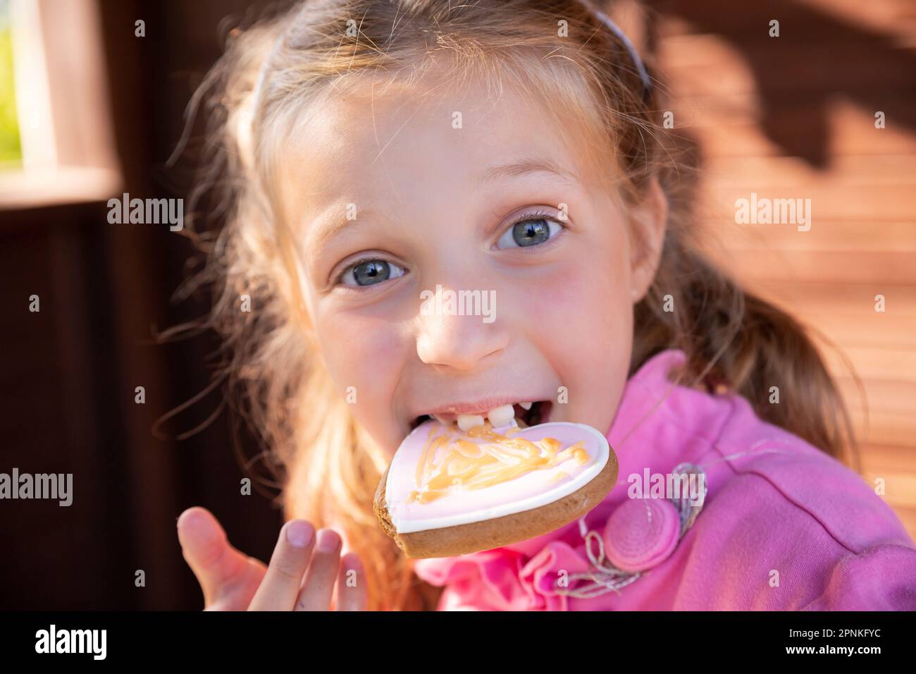 smiling teen girl eat oatmeal cookies on blurred background.Happy blond ...