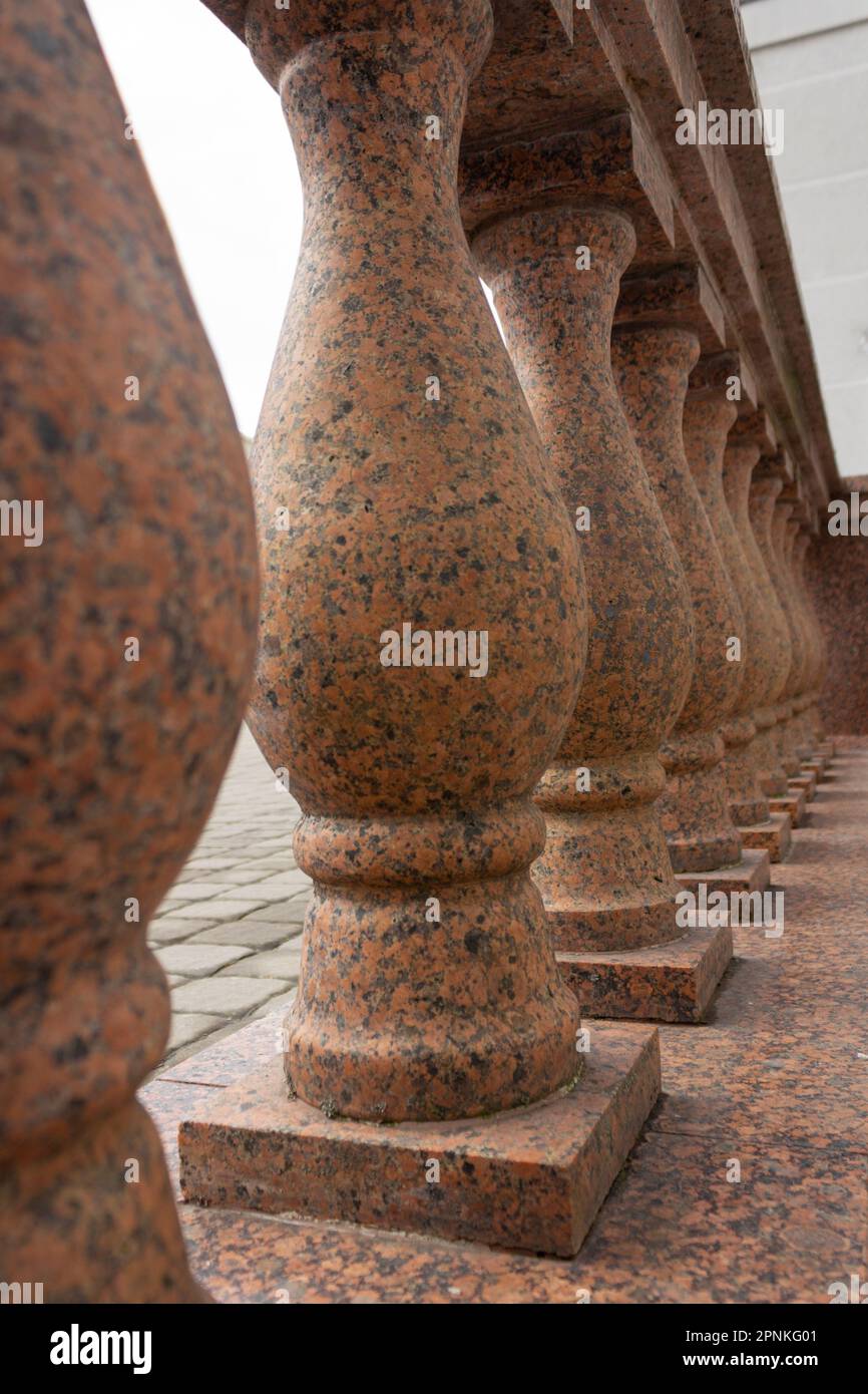 Old terrace balusters made of pink granite. Abstract classical ...