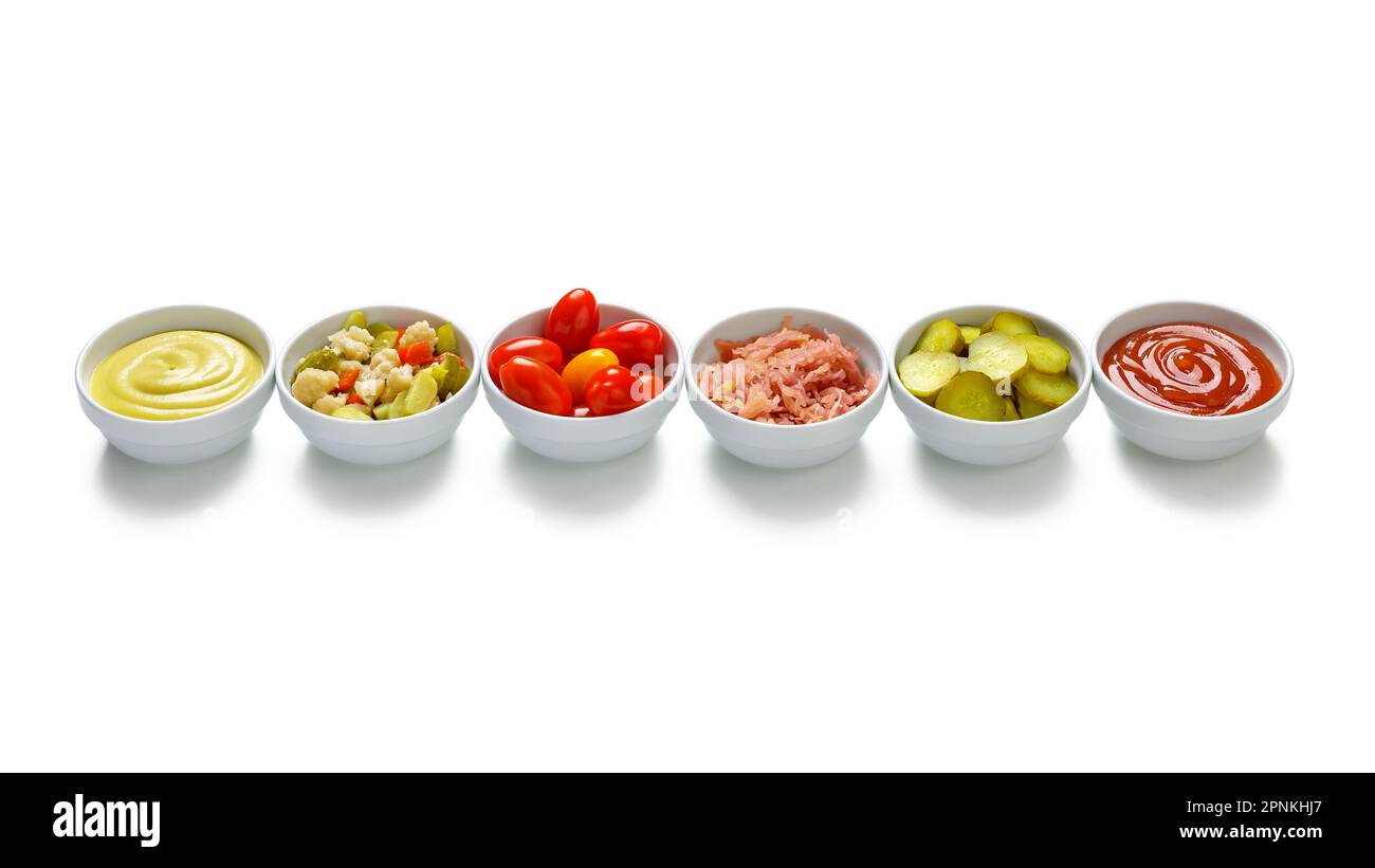 Row of vegetable bowls with cucumbers, ketchup, tomatoes, mustard ...