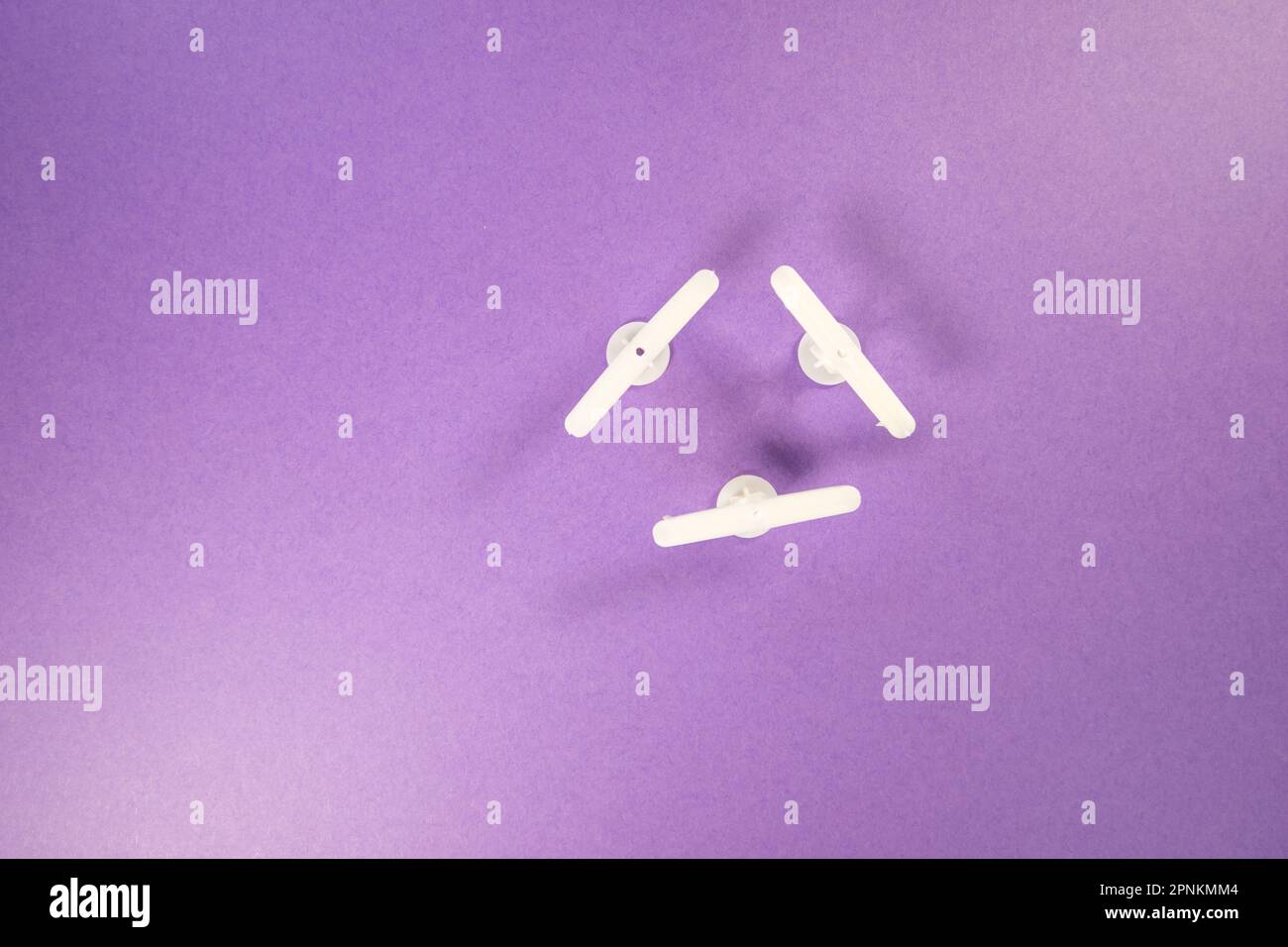 three plastic toggle fixings for plasterboard hollow walls isolated on ...