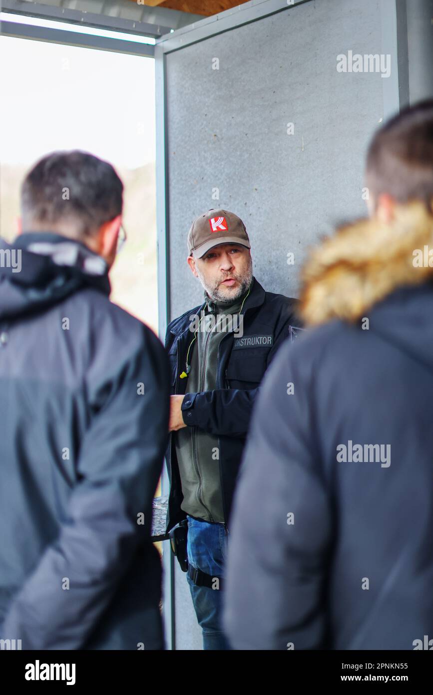 Instructor man, gun and learning to shoot outdoor at shooting range for ...