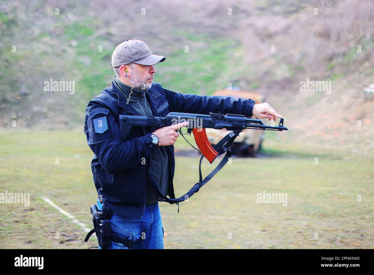 Instructor man, gun and learning to shoot outdoor at shooting range for ...