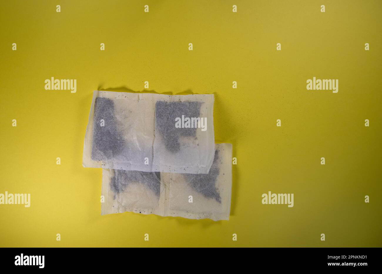 two pairs of square tea bags isolated on a yellow background Stock ...