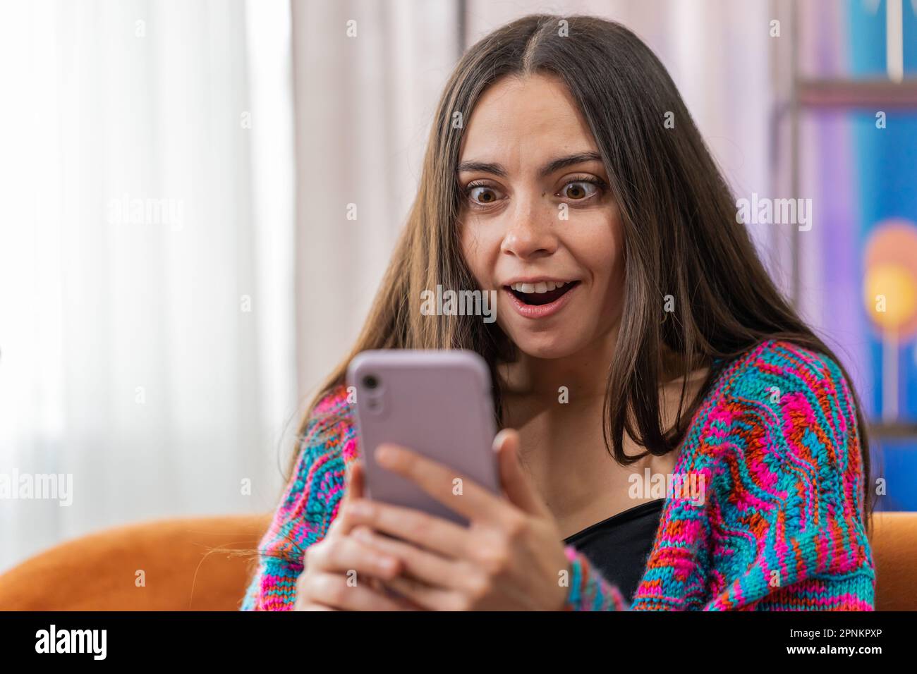 Oh my God Wow. Excited happy young woman use smartphone typing browsing ...