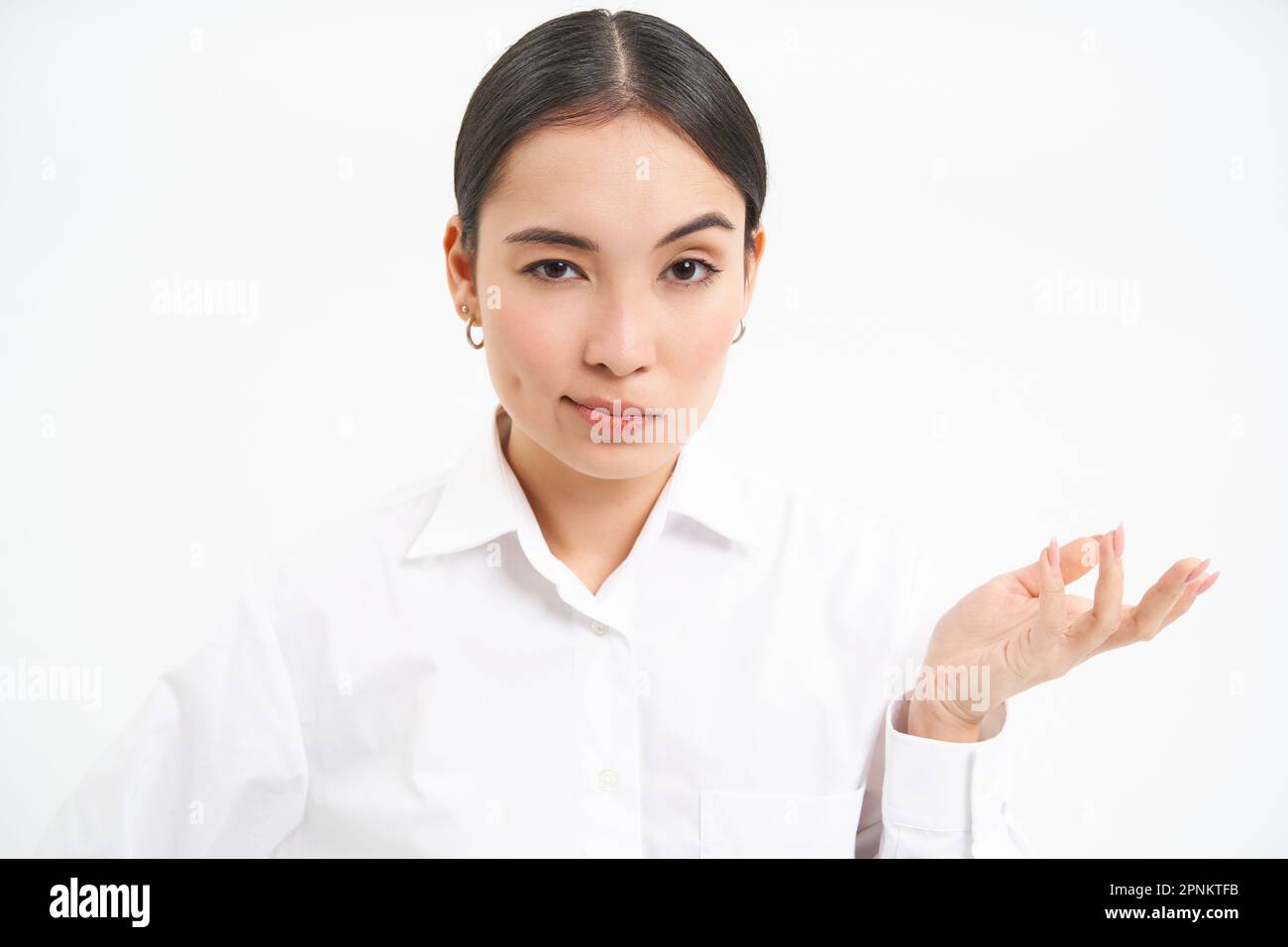 Portrait of skeptical asian woman, looks unamused and serious at camera ...