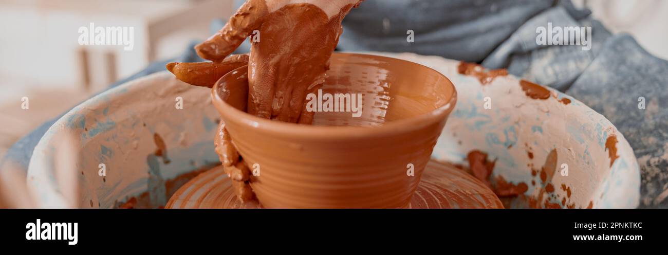 Skillful female potter creating earthen bowl on circle in workroom ...