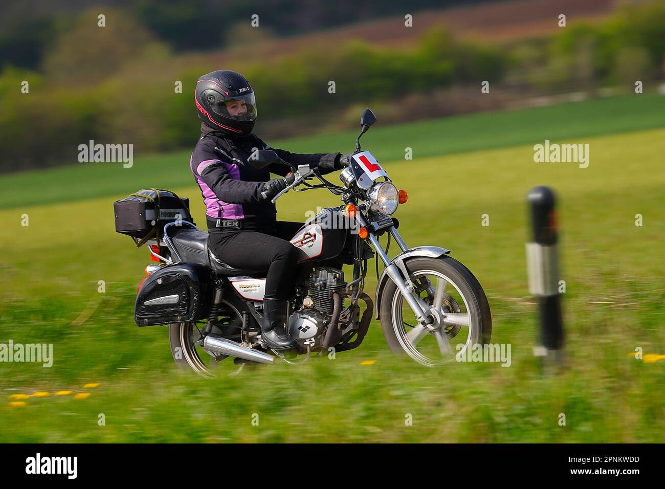 A woman learner motorcyclist riding a Huoniao 125-8 along the B1222 ...