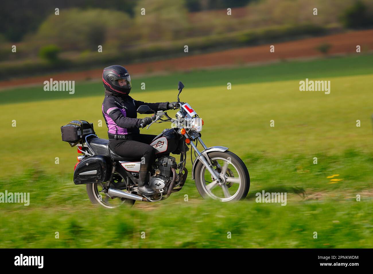 A woman learner motorcyclist riding a Huoniao 125-8 along the B1222 ...