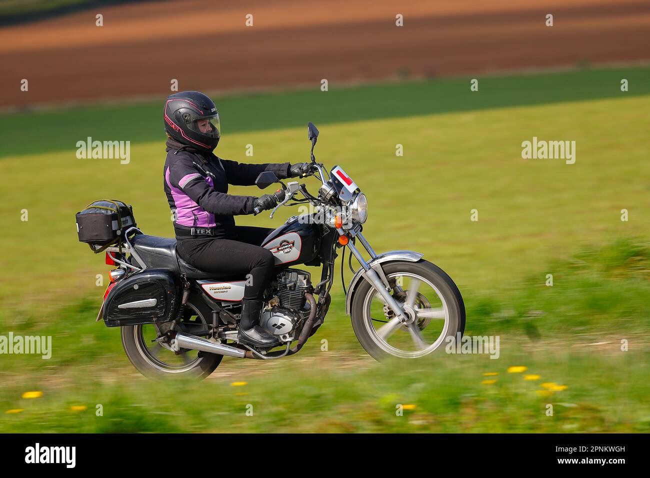 A woman learner motorcyclist riding a Huoniao 125-8 along the B1222 ...