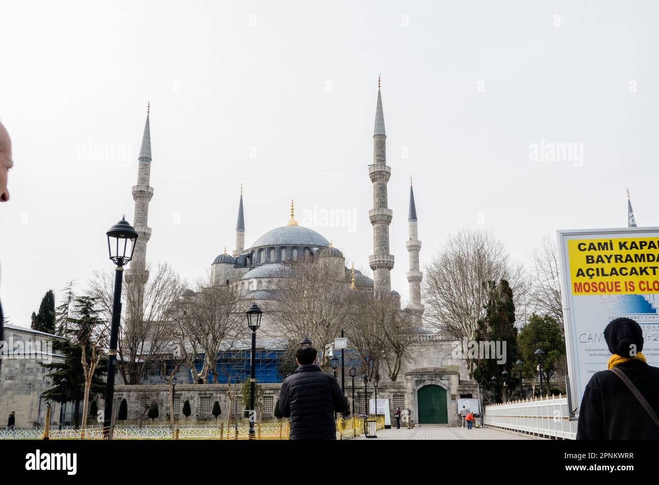 Tourists walk by famous Blue Mosque in Sultanahmet area of Istanbul ...