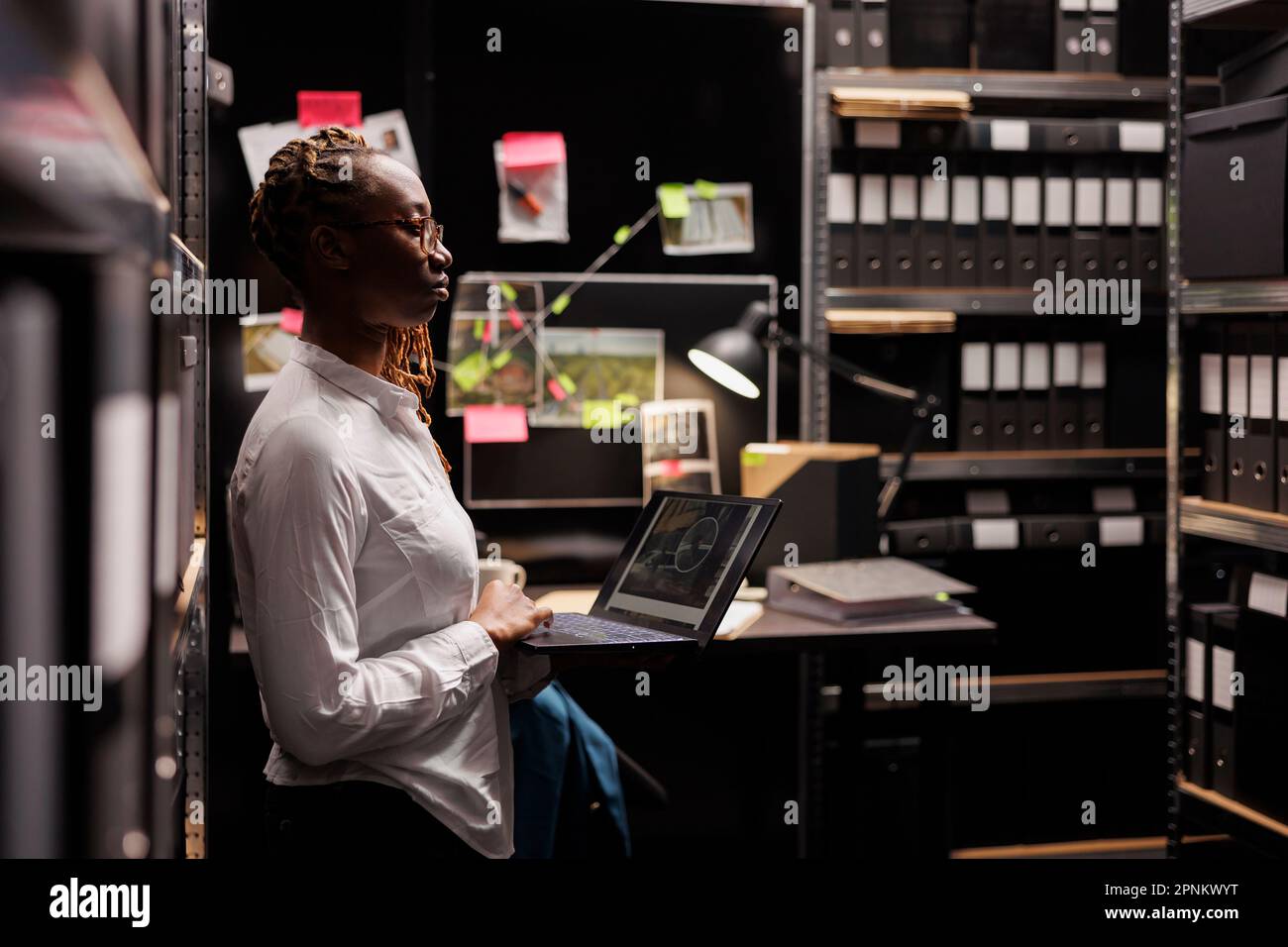 Woman detective checking evidence photo on laptop and solving crime ...