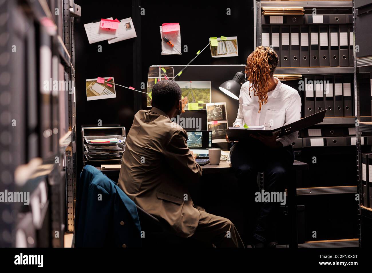 Detective Partners Analyzing Surveillance Photos Hanging On Evidence
