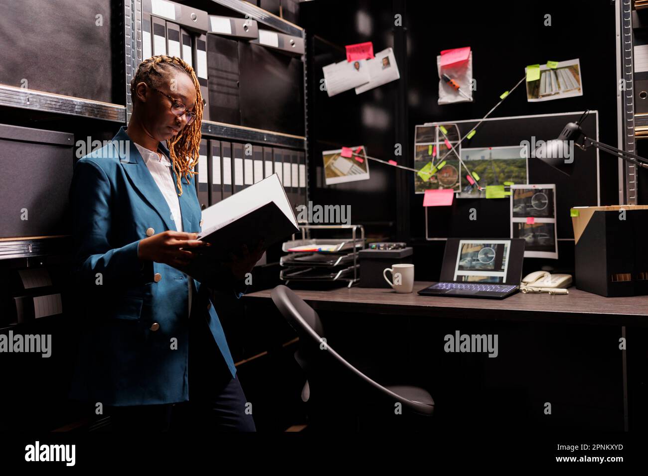 African american woman police investigator reading case file in office ...