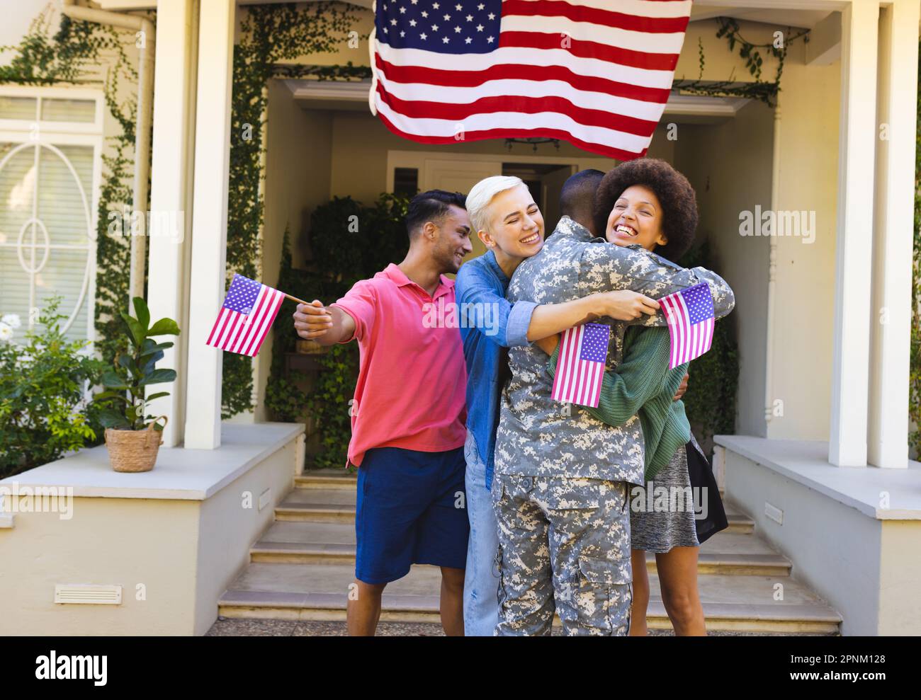 Happy diverse group of friends with usa flags, greeting biracial male ...