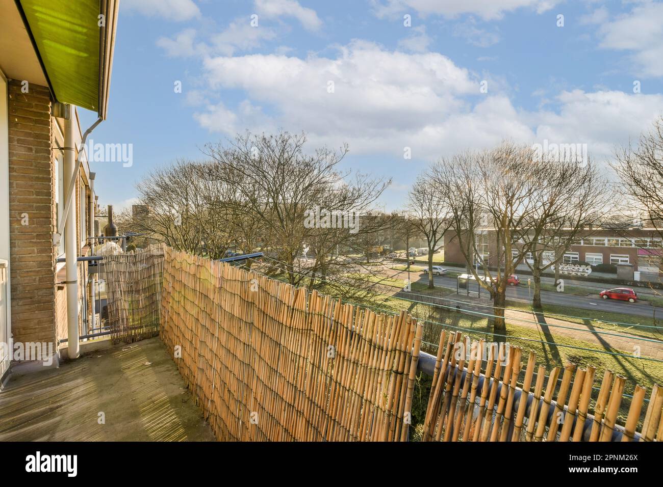 a wooden fence in front of a house with cars parked on the other side ...