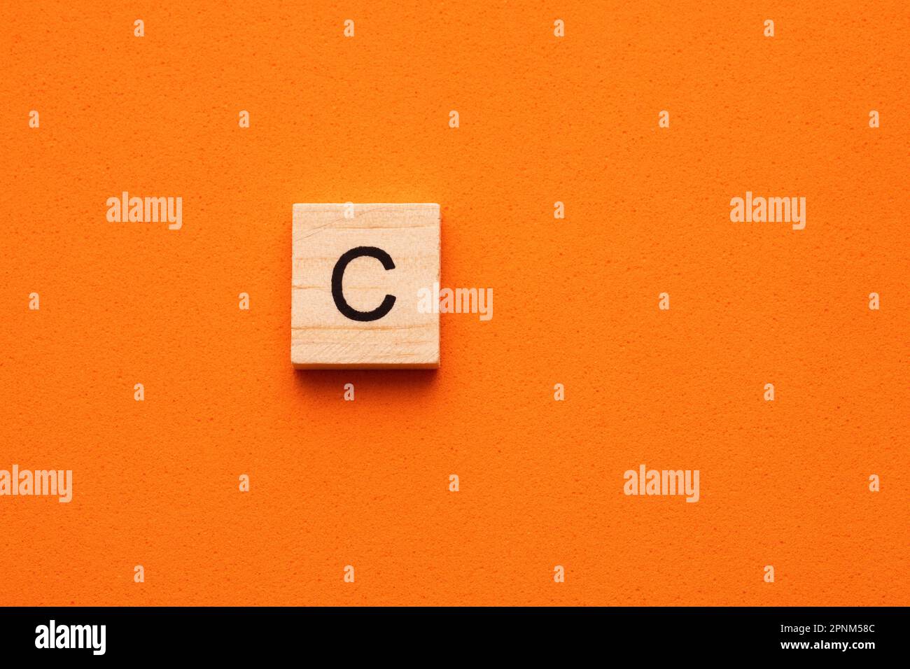 Alphabet letter C on wooden square tile - Orange foamy background Stock ...