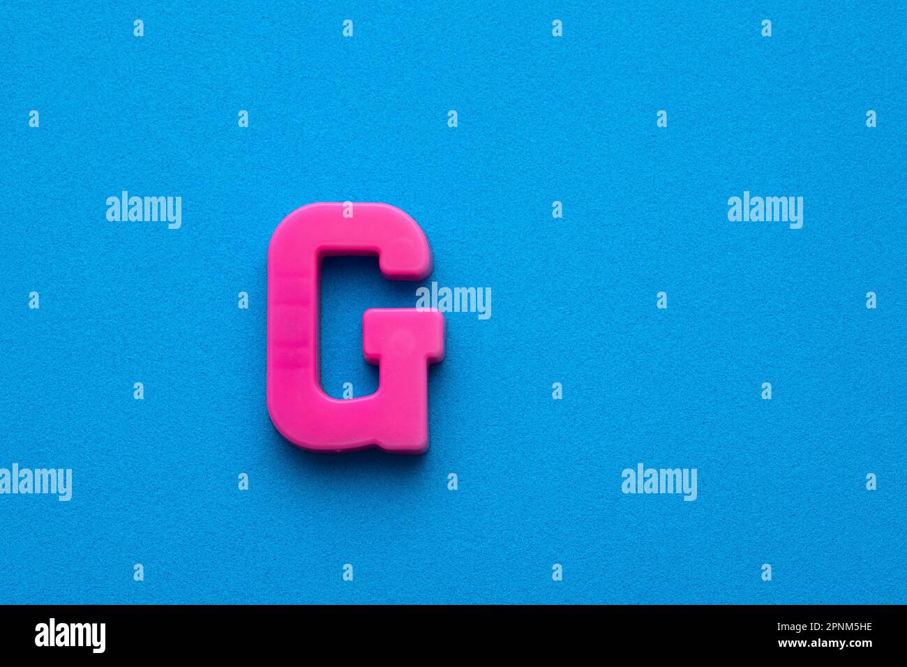 Plastic pink letter G uppercase on blue foamy background Stock Photo ...
