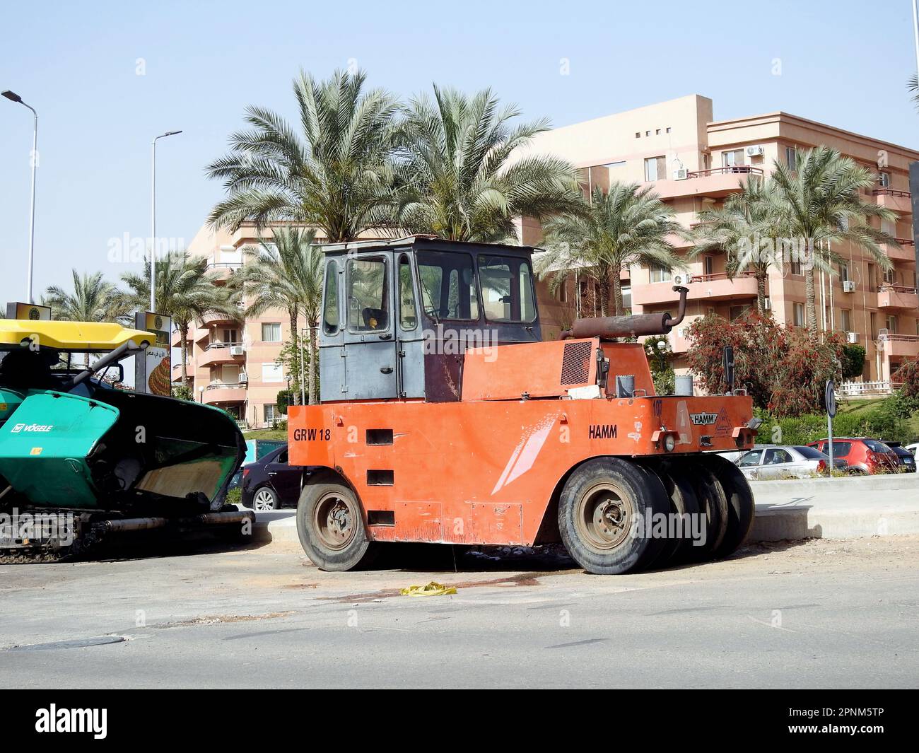 Cairo, Egypt, April 18 2023: Asphalt paver trucks and compactors, A ...