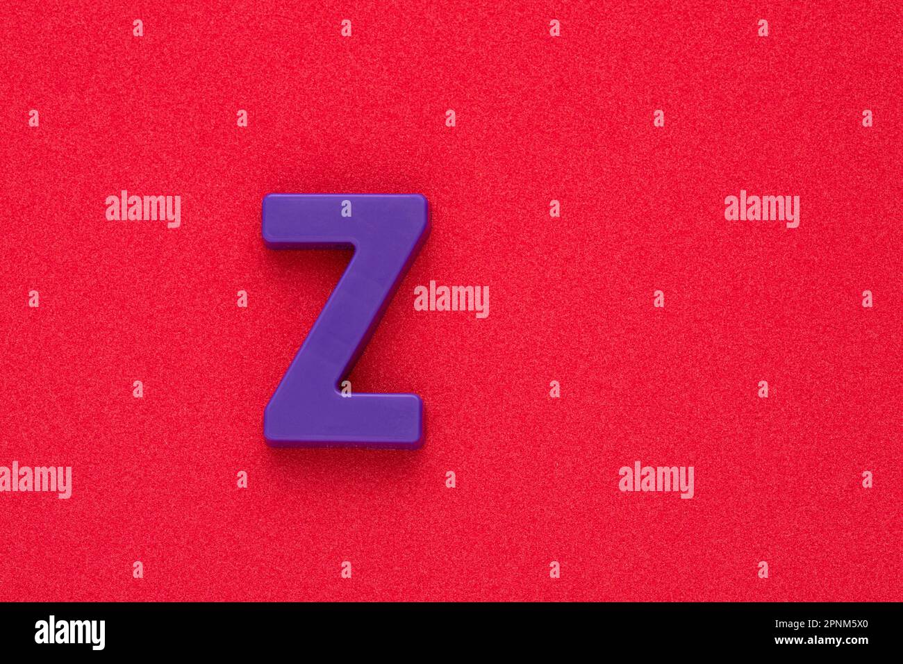 Alphabet letter Z - Violet colored plastic piece on red 032 c foamy ...