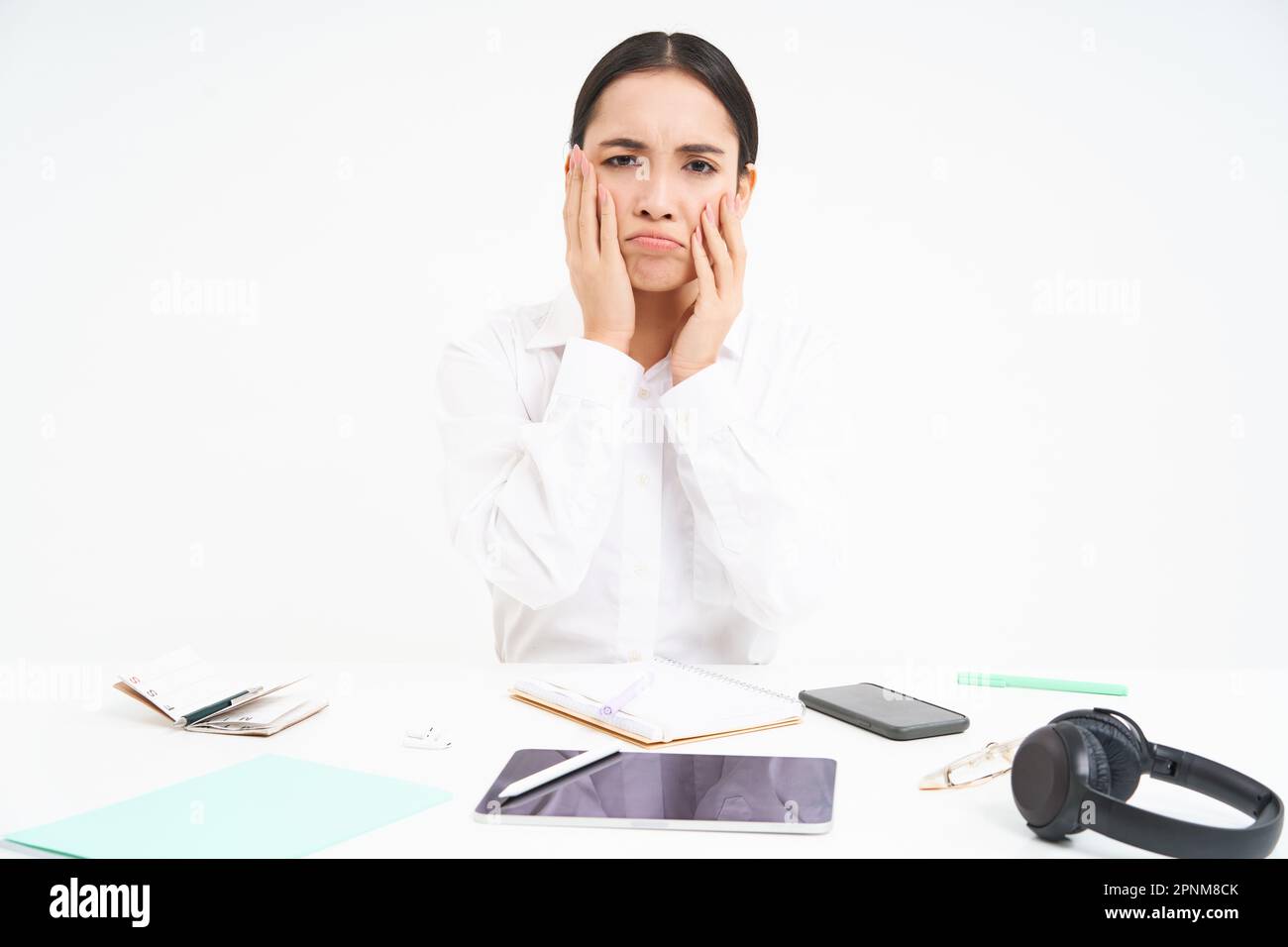 Sad and grumpy asian woman at workplace, sits with digital tablet and ...