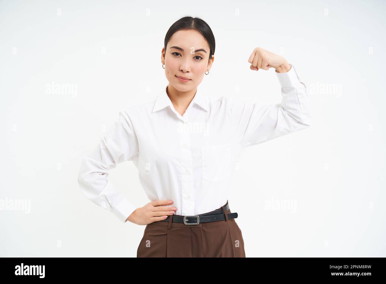 Confident asian businesswoman, flexing biceps, shows strong muscle with ...