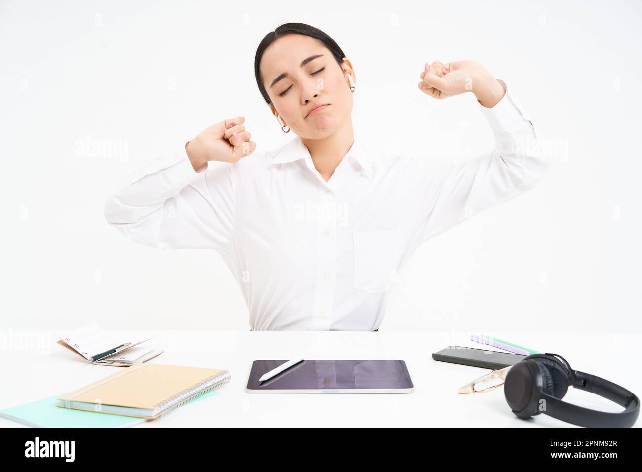 Tired businesswoman in office, sits back and stretches hands, exhausted ...