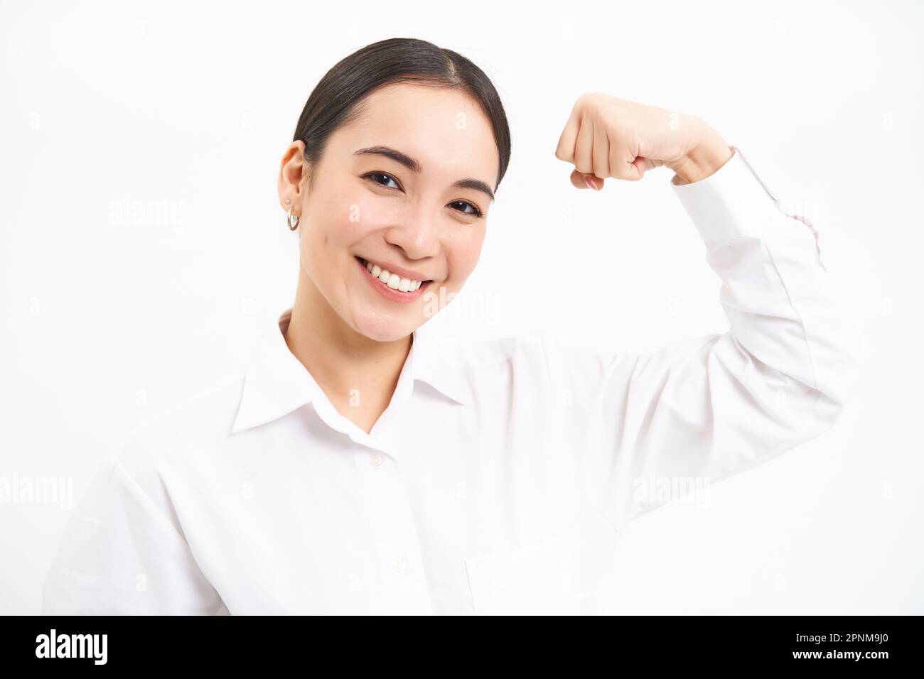 Portrait of confident and strong businesswoman, flexing biceps, shows ...