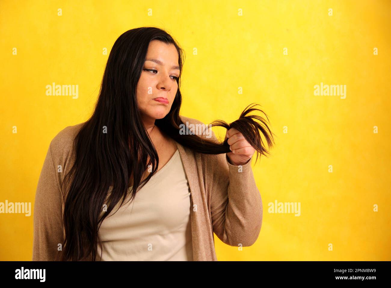 Latin adult woman with very long straight hair suffers and is sad ...