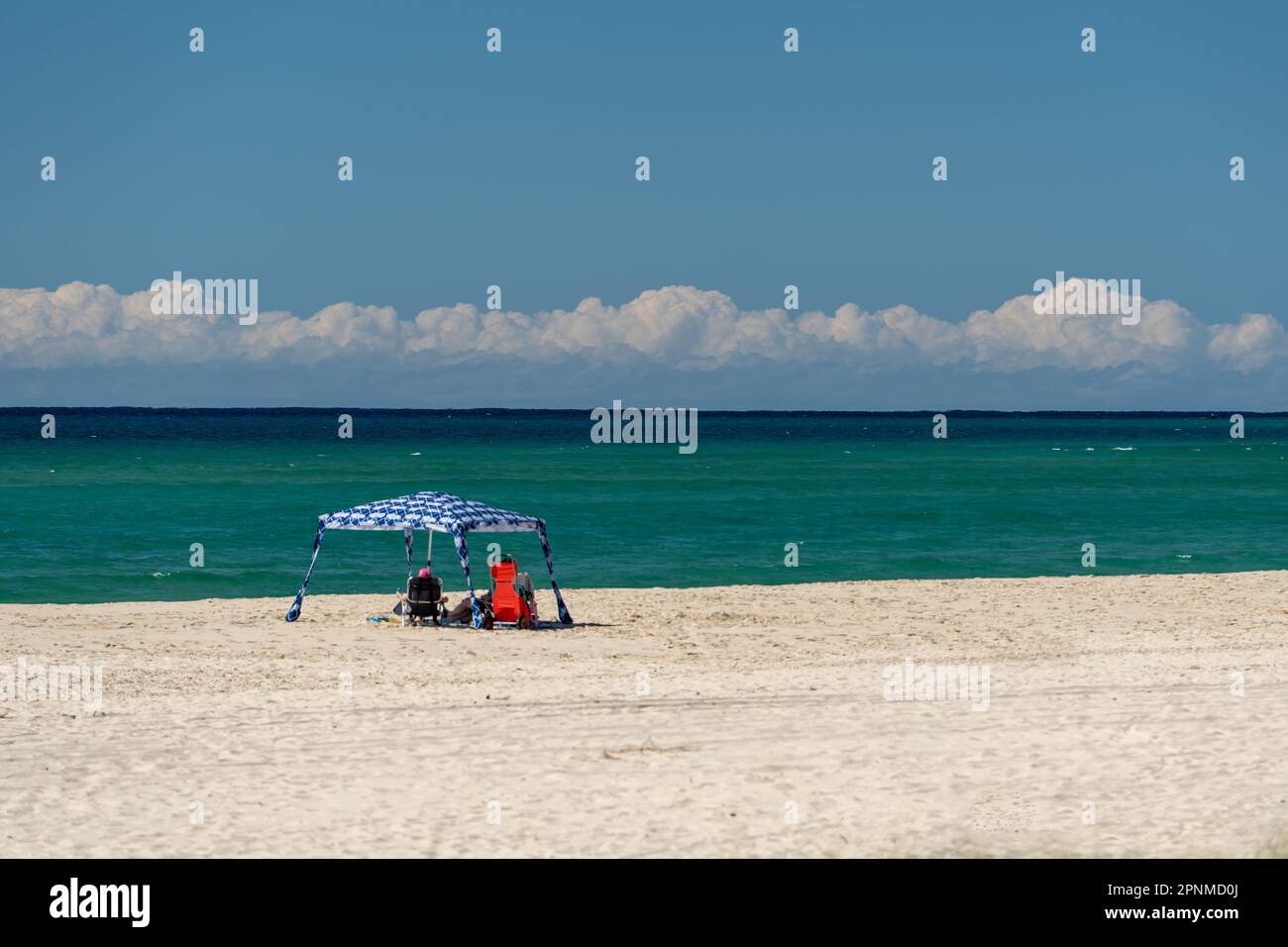 Two people relaxing under a beach shade at Kirra Beach, Queensland ...