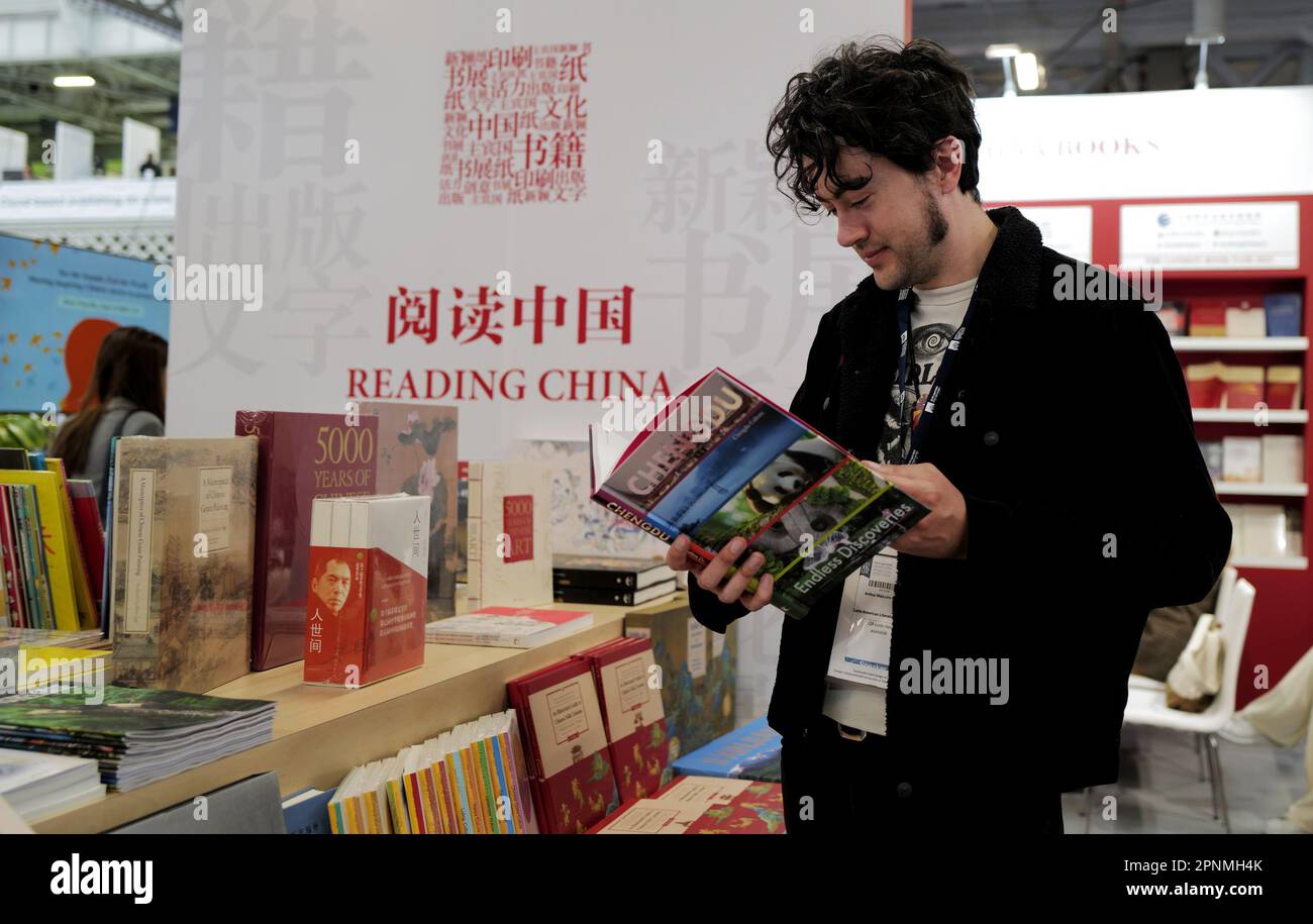 London, Britain. 18th Apr, 2023. A man reads at a booth displaying ...