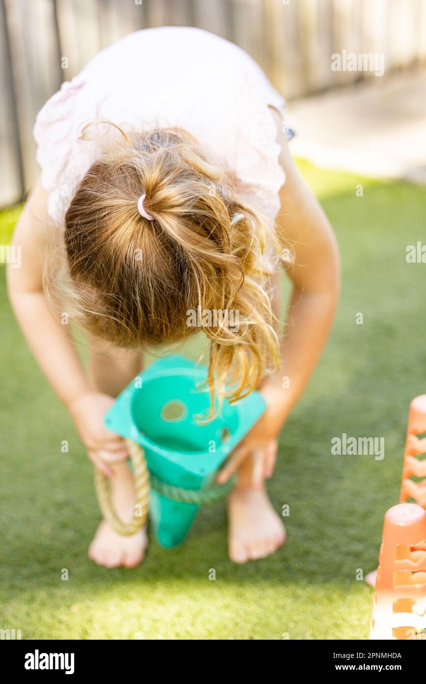 Preschool age child playing in a vibrant fun outdoor kindergarten yard ...