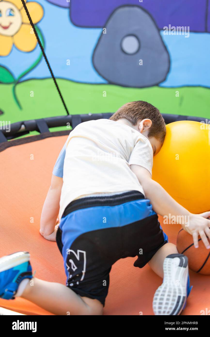 Preschool age child playing in a vibrant fun outdoor kindergarten yard ...