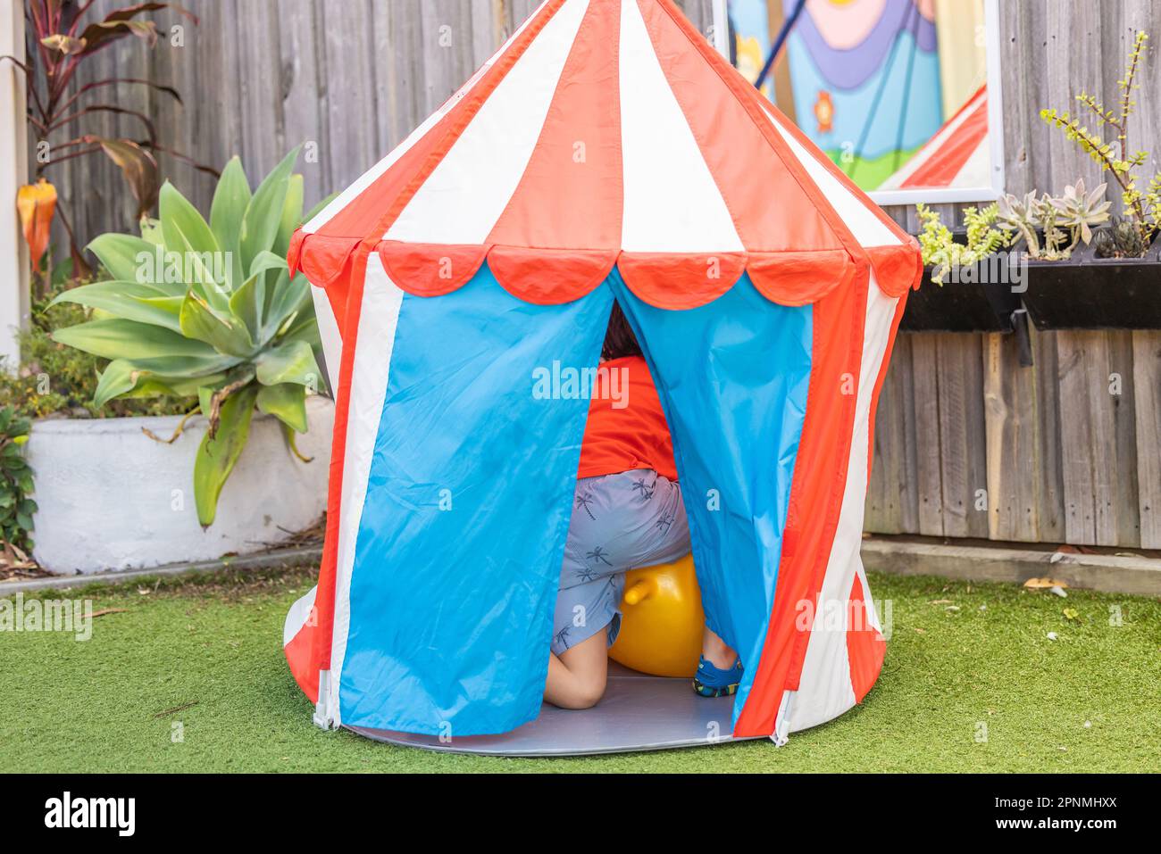 Preschool age child playing in circus tent in a vibrant fun outdoor ...