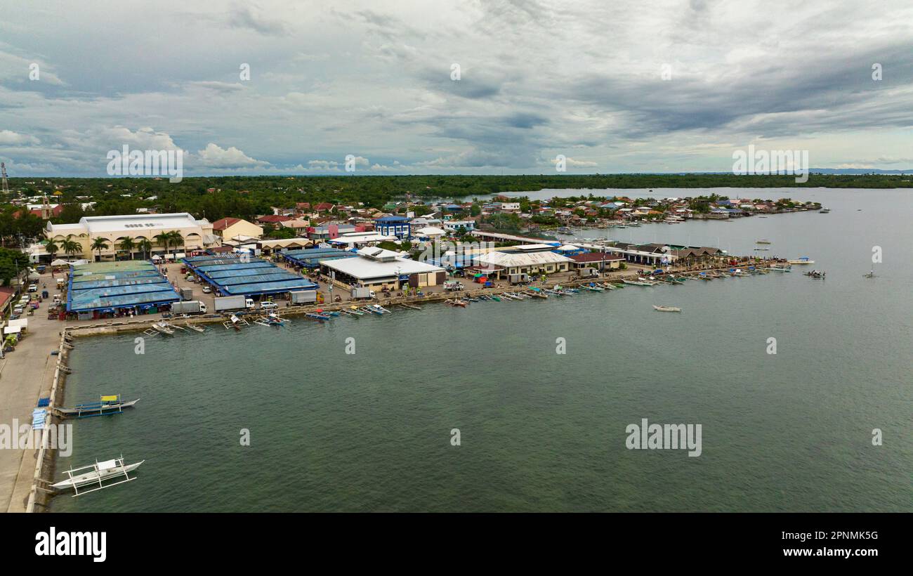Aerial view of town on the seashore with a pier and boats. Bantayan ...