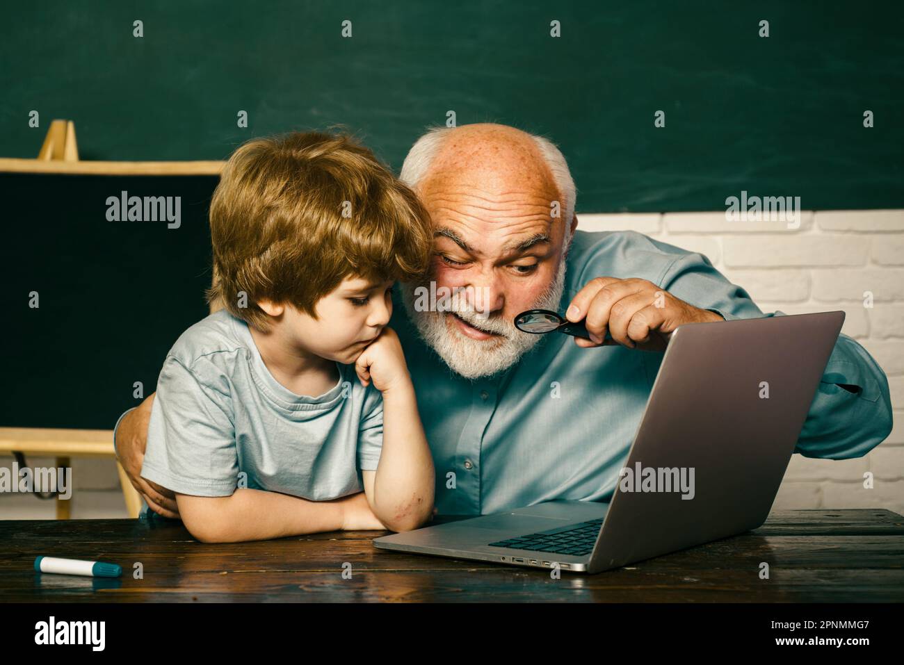 Elementary school, kid and teacher with laptop in classroom at school ...