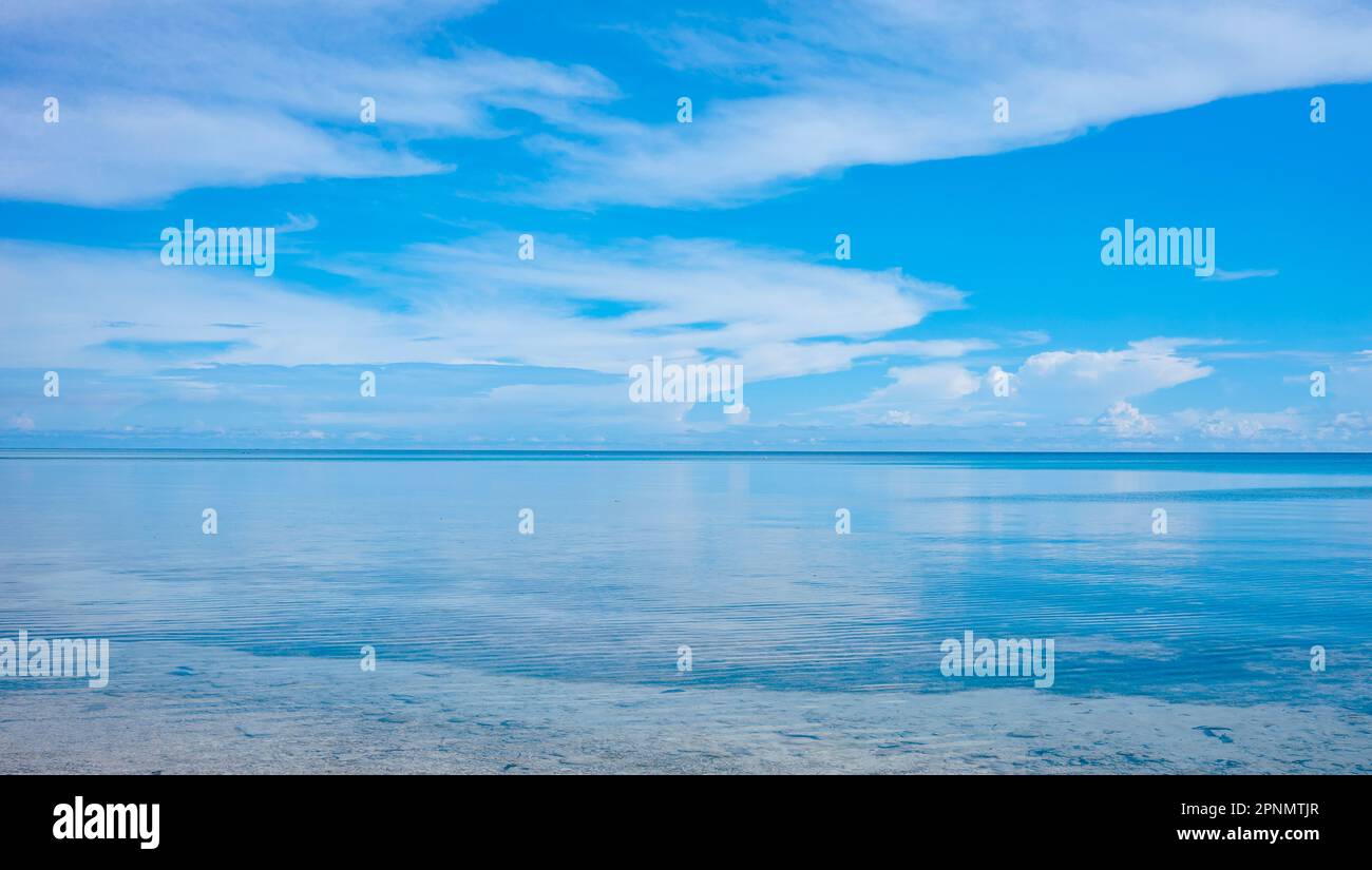 Calm sea with blue sky and light clouds with plenty of copy space ...
