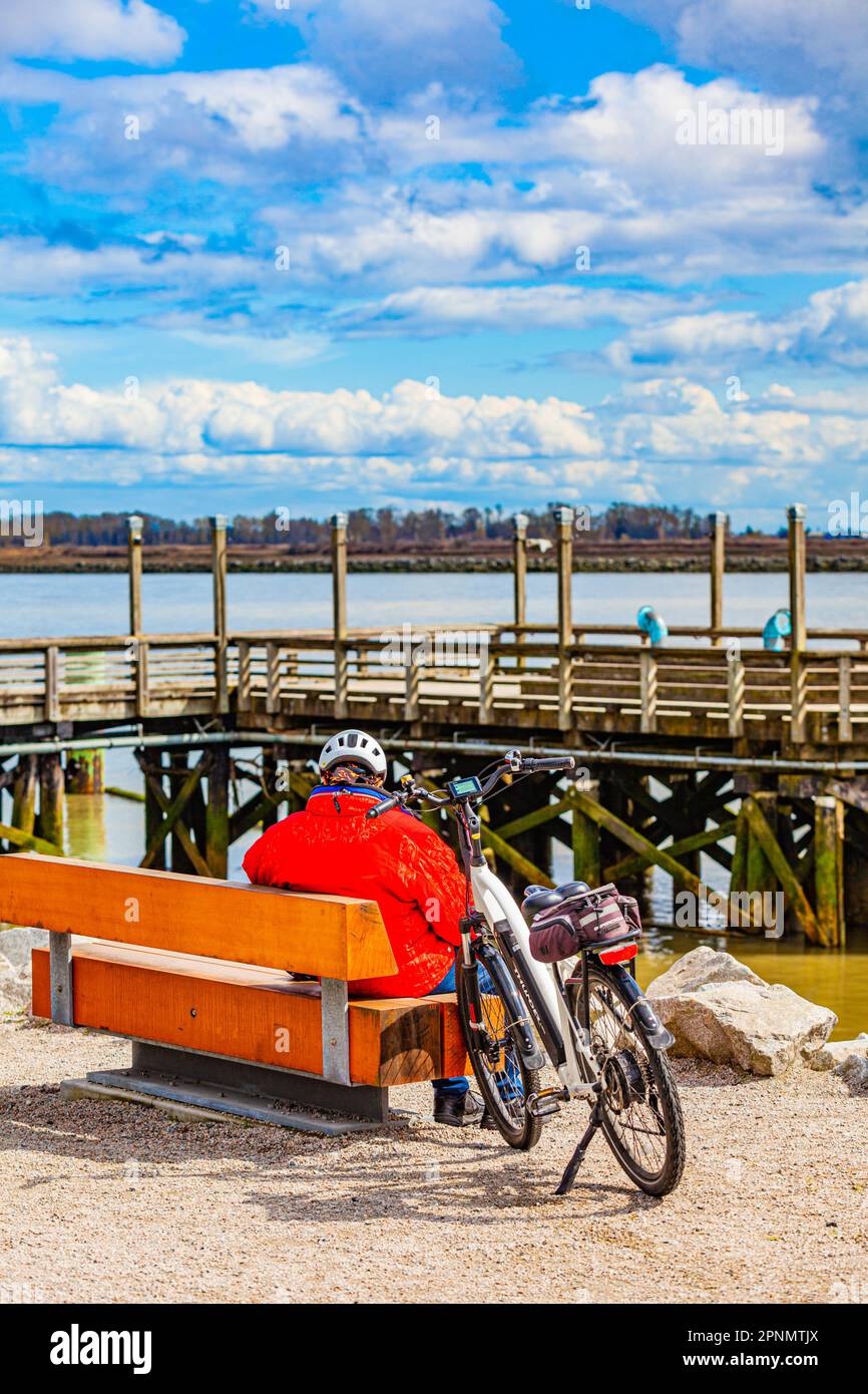 Older gentleman with his battery assist bike resting on the bank of the ...