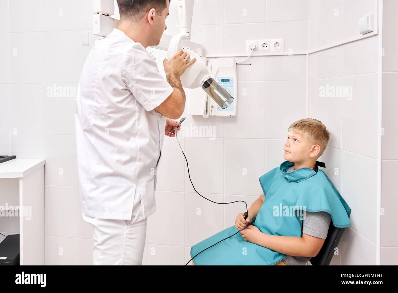 Radiographer taking teeth radiography to a boy using digital x-ray ...