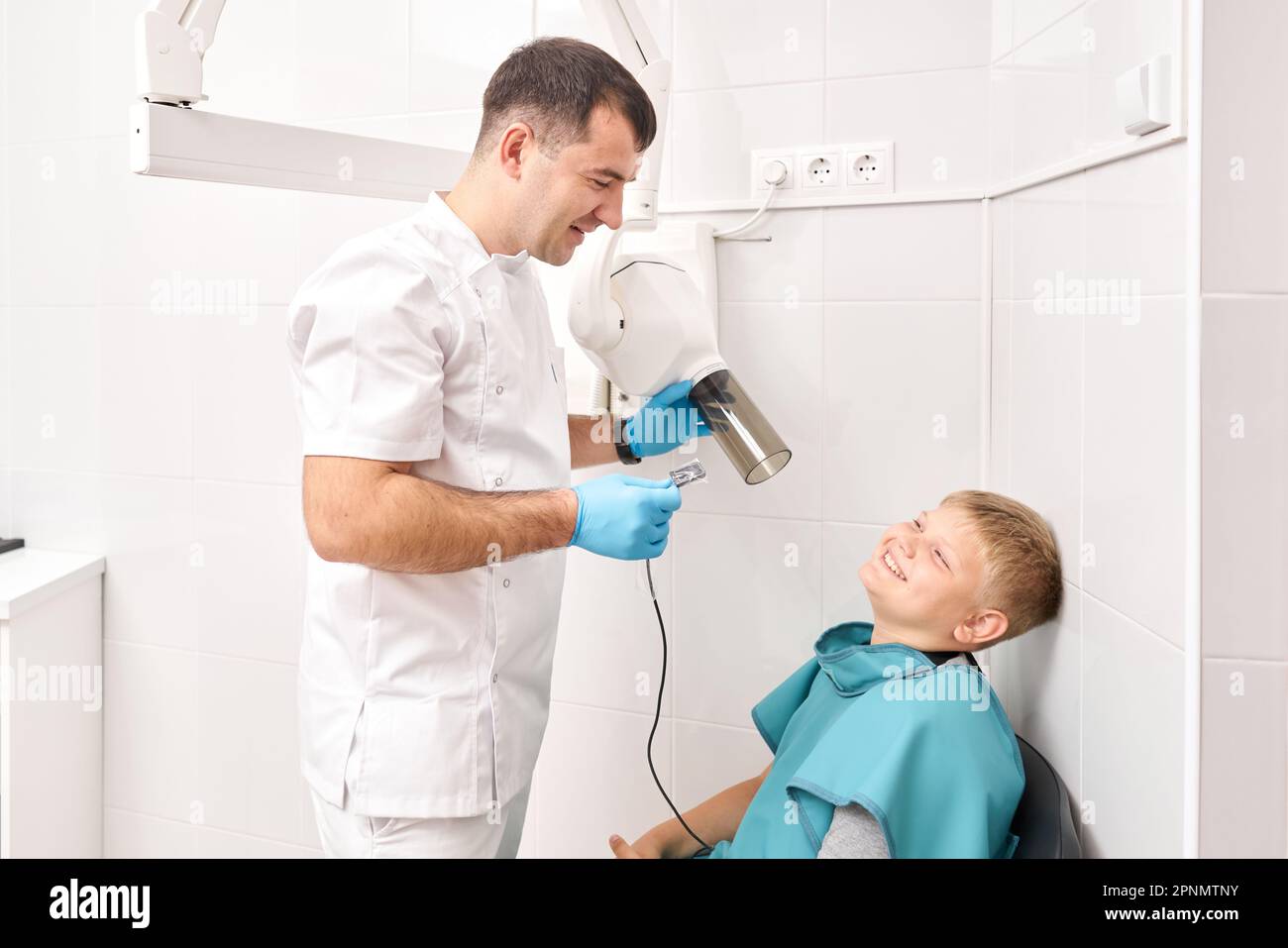 Radiographer taking teeth radiography to a boy using digital x-ray ...