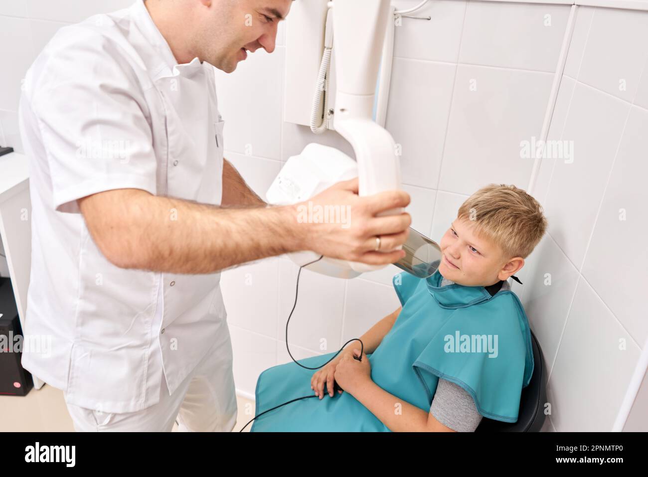 Radiographer taking teeth radiography to a boy using digital x-ray ...