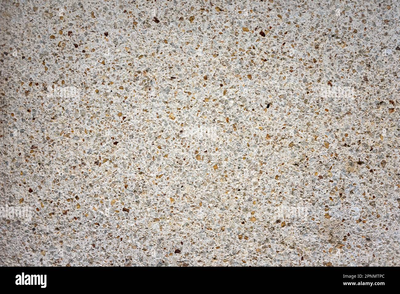 texture of a house facade made of gray concrete with small stones. A ...